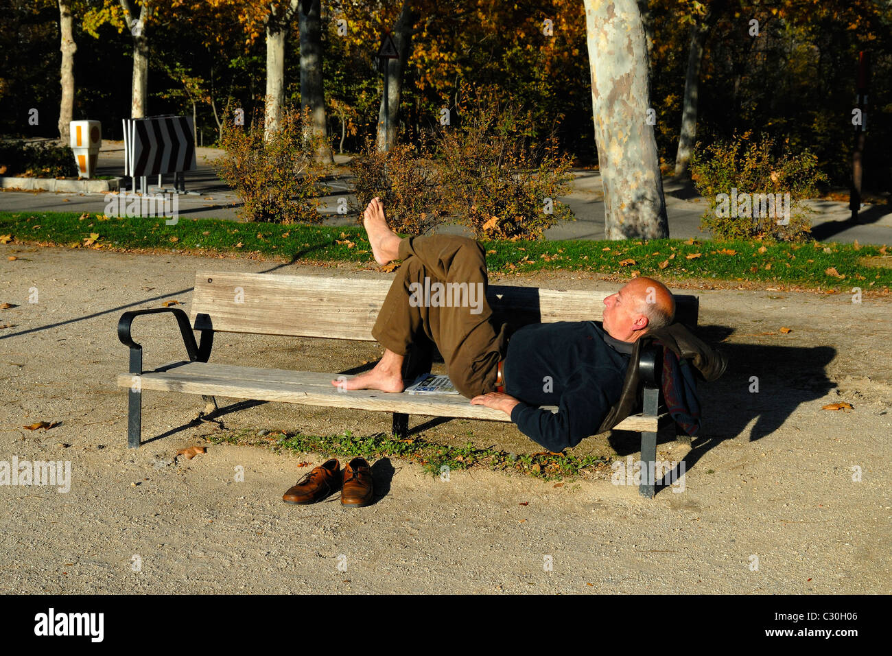 Old man taking a nap on a park bench in Madrid, Spain Stock Photo - Alamy