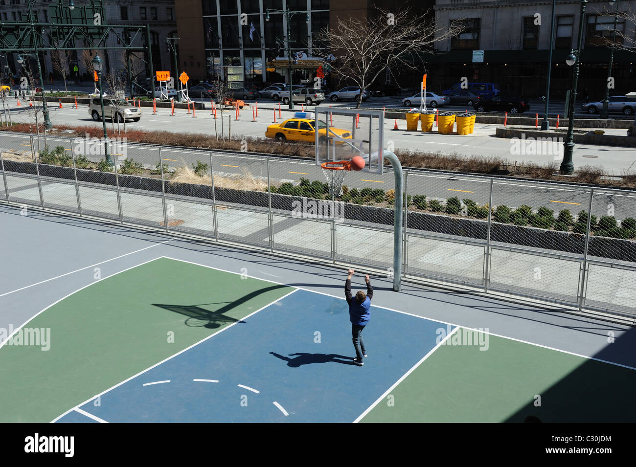 A boy playing basketball in a court near the West Side highway in Lower ...