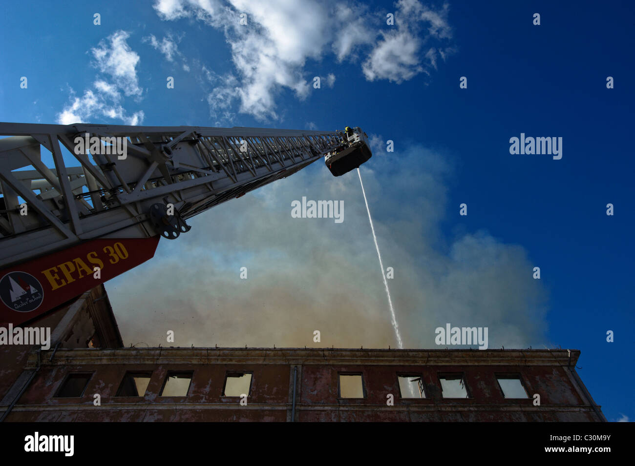 Firemen fighting urban fire with telescopic ladder Stock Photo - Alamy