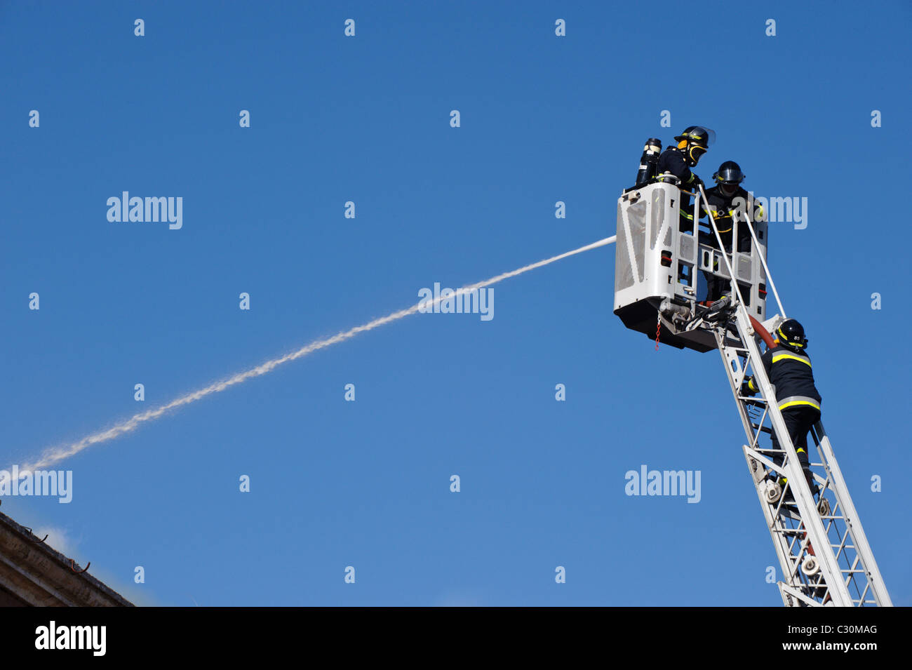 Firemen fighting fire with telescopic ladder Stock Photo - Alamy