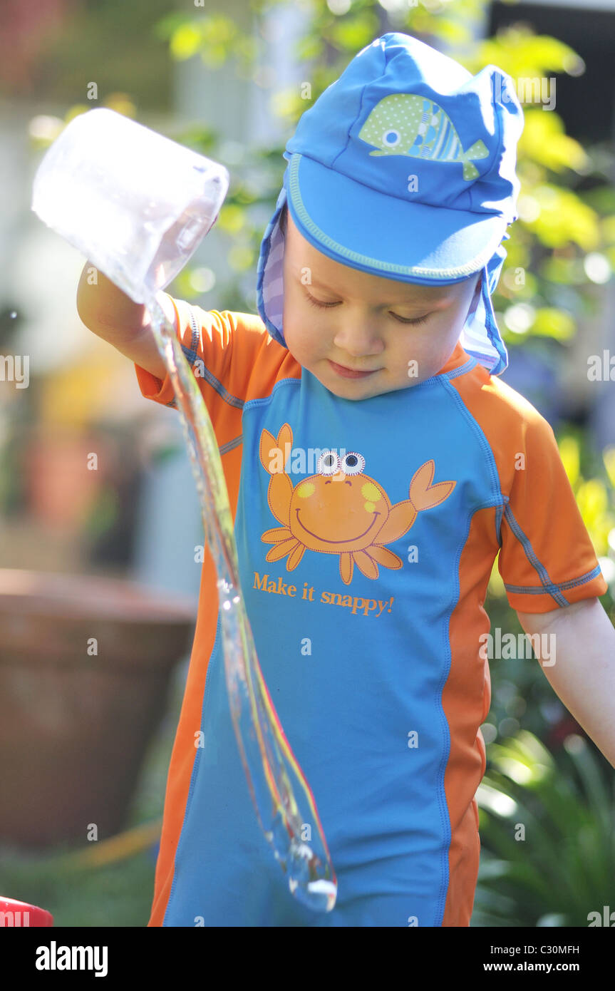 Little 18 months old boy playing with a jug and water Stock Photo - Alamy