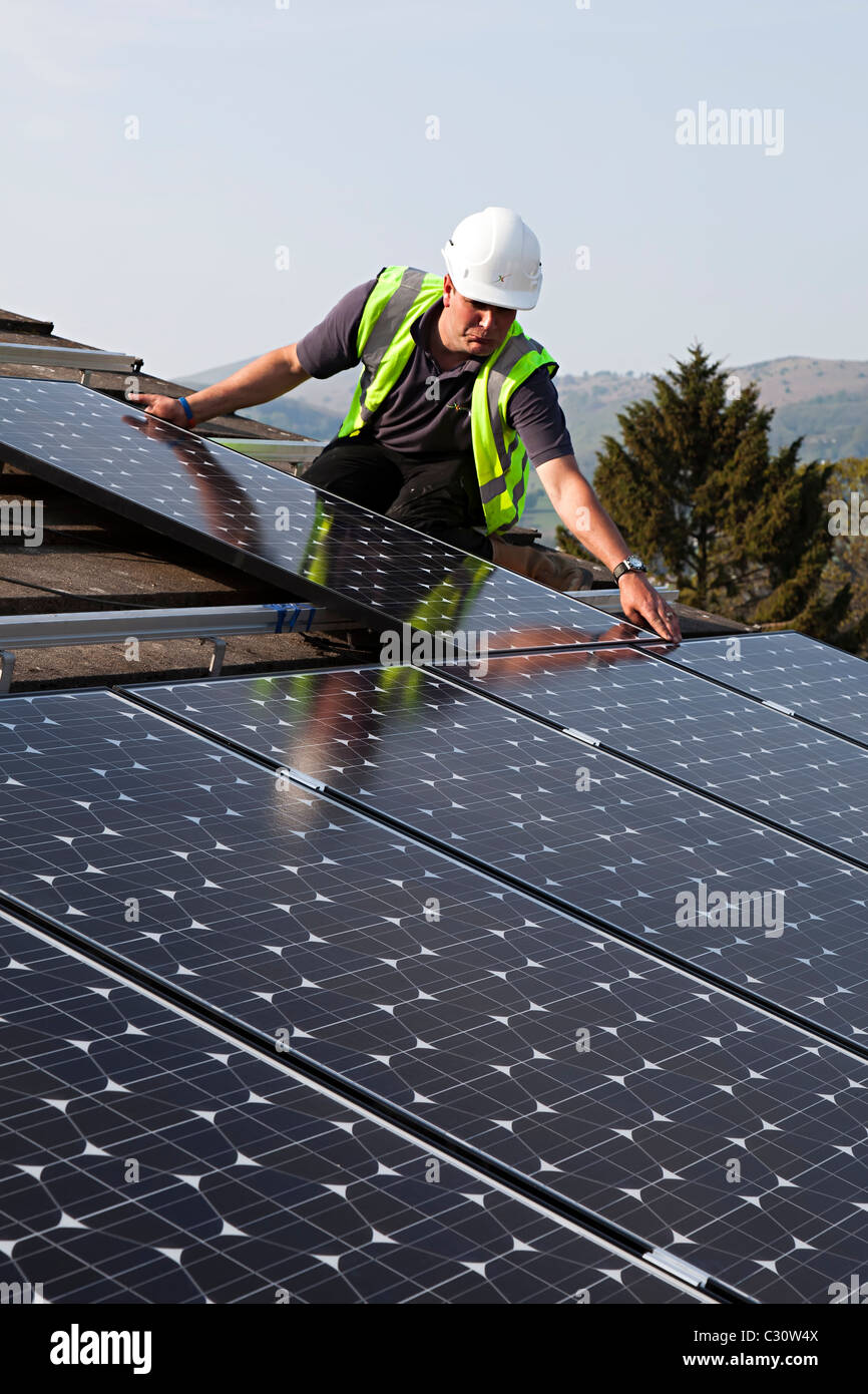 Fitting solar pv panels to a house roof Wales UK Stock Photo - Alamy
