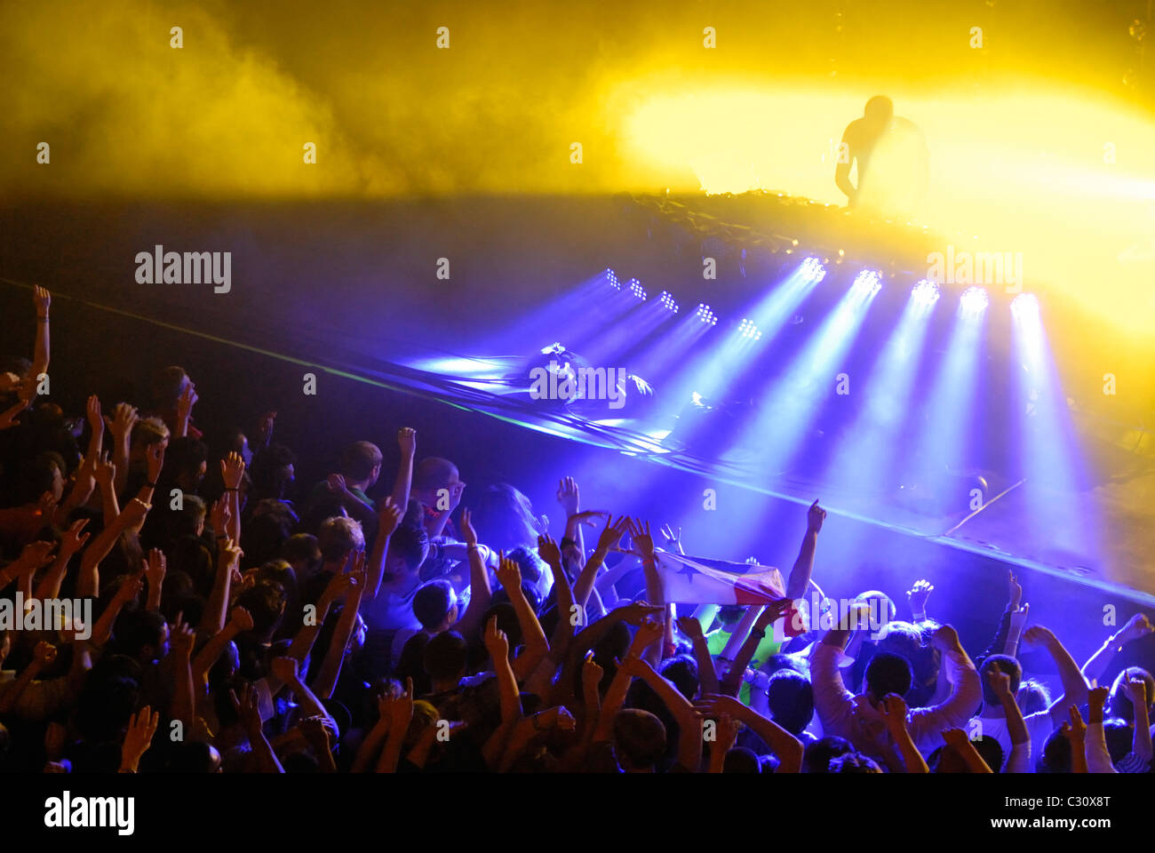 DJ with light show and crowd at concert, club or rave. Members of the ...