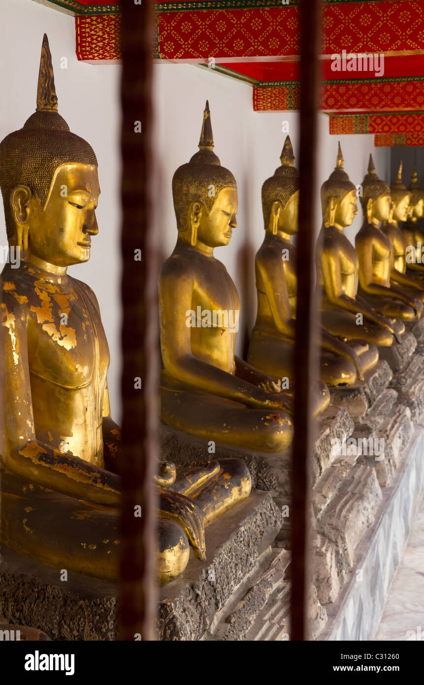 Row of Seated Golden Buddhas Through Barred Window at Buddhist Temple ...