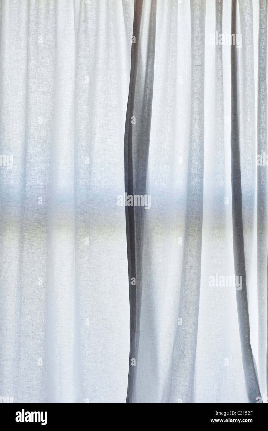 White cotton curtains with daylight filtering through on a Spring day ...