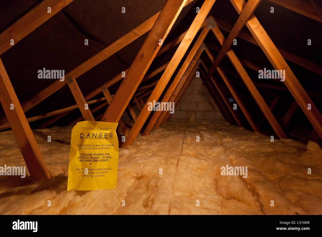Inside a house loft putting extra insulation to increase warmth and ...