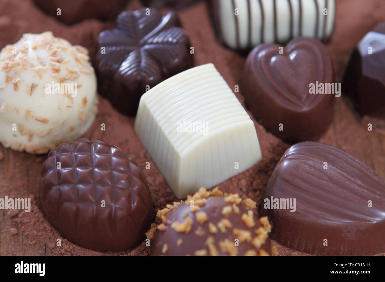 Various types of pralines isolated on chocolate background Stock Photo ...