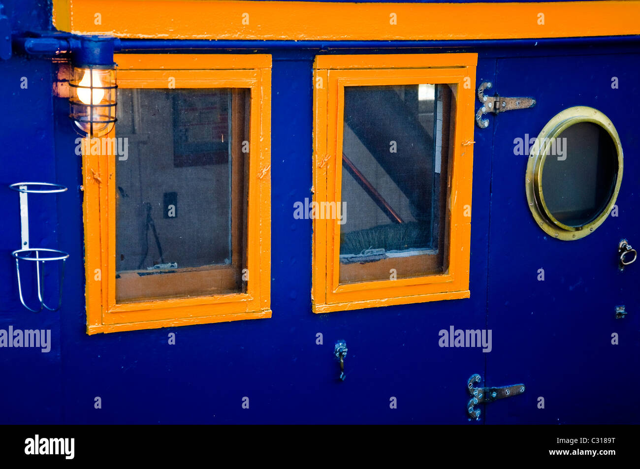 Yellow framed Window and round window of a marine boat Stock Photo - Alamy