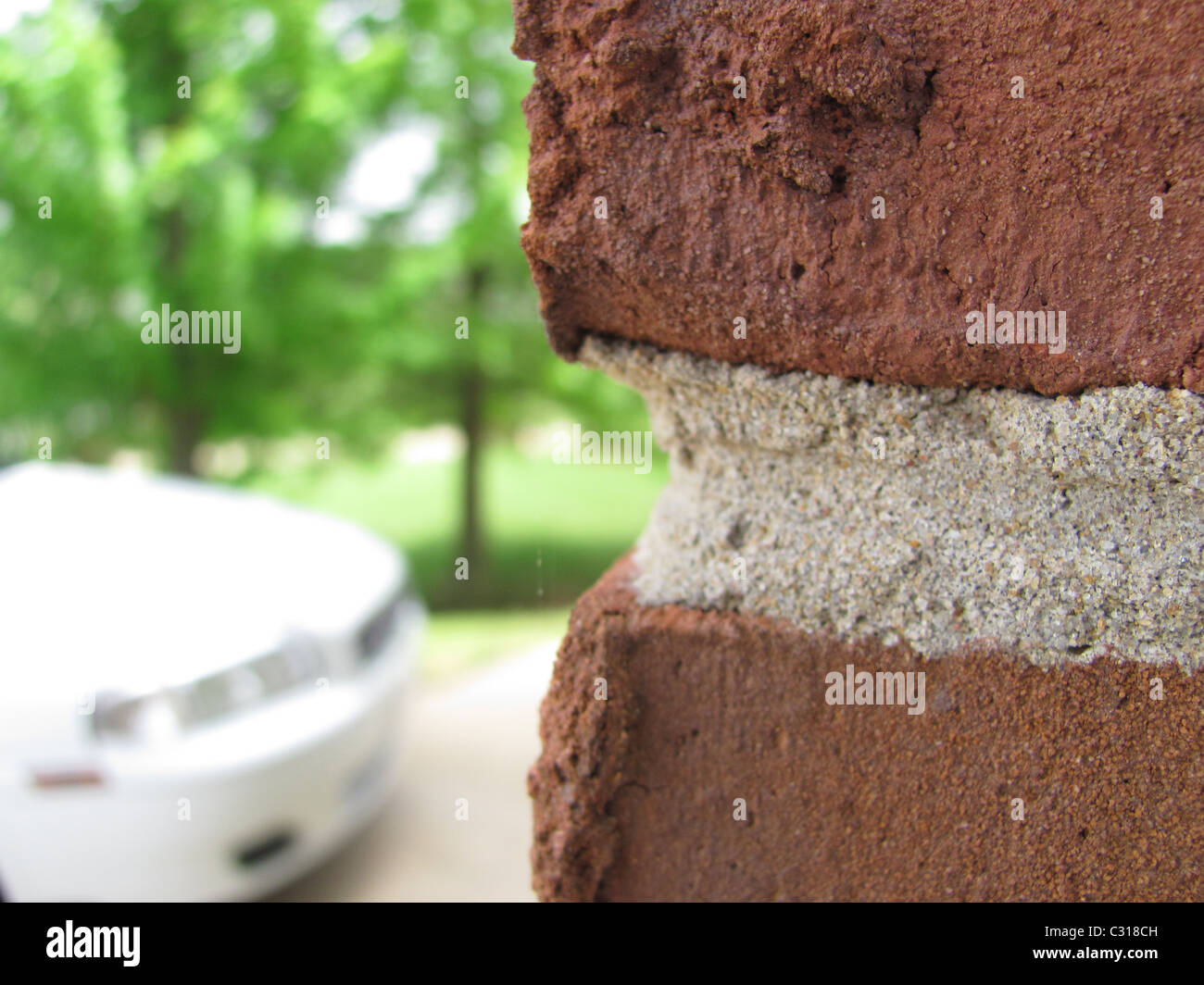 A brick wall with a car in the background Stock Photo - Alamy