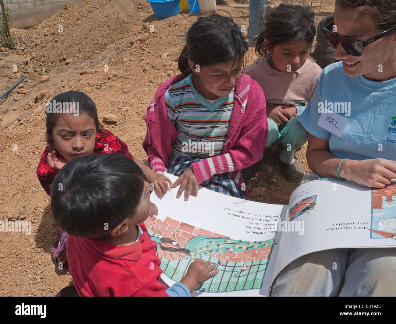 A Habitat for Humanity volunteer reads to Guatemalan children during a ...