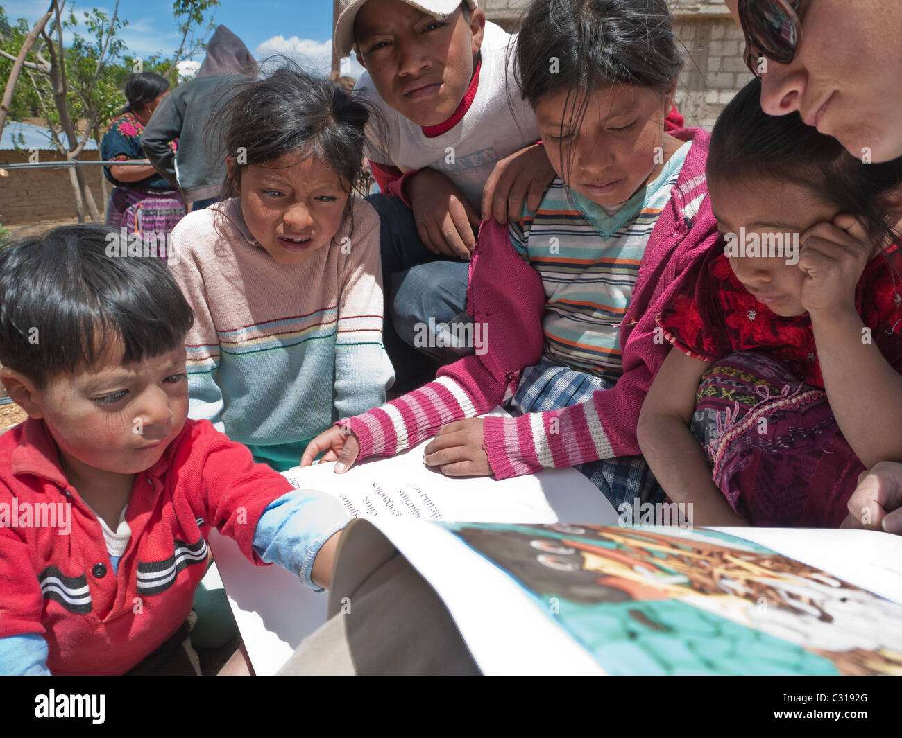 A Habitat for Humanity volunteer reads to Guatemalan children during a ...