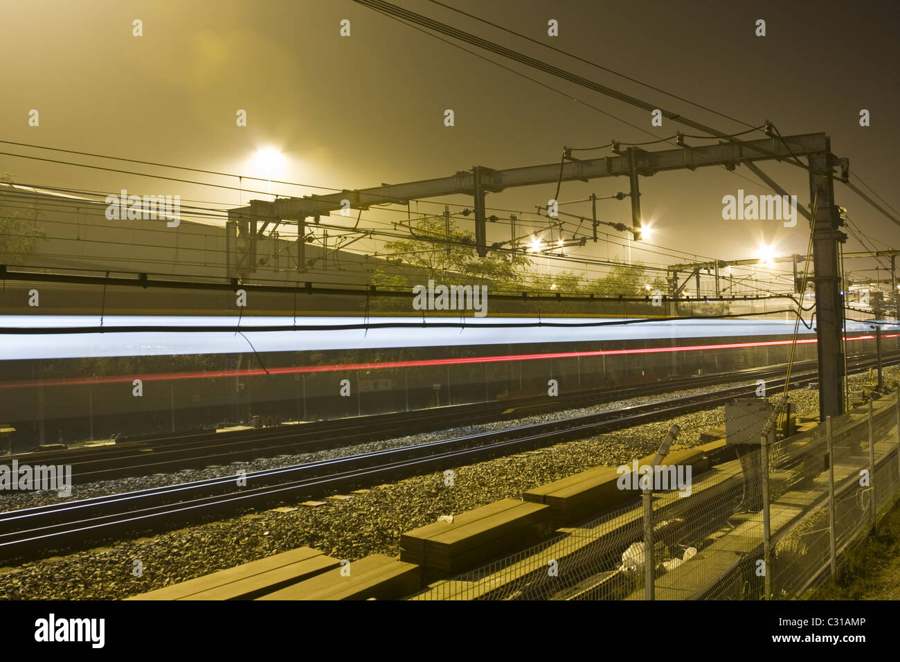 Rails by night with reflecting neon light Stock Photo - Alamy