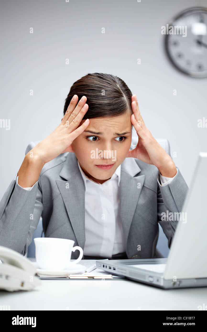 Image of young employer looking at laptop with troubled expression ...