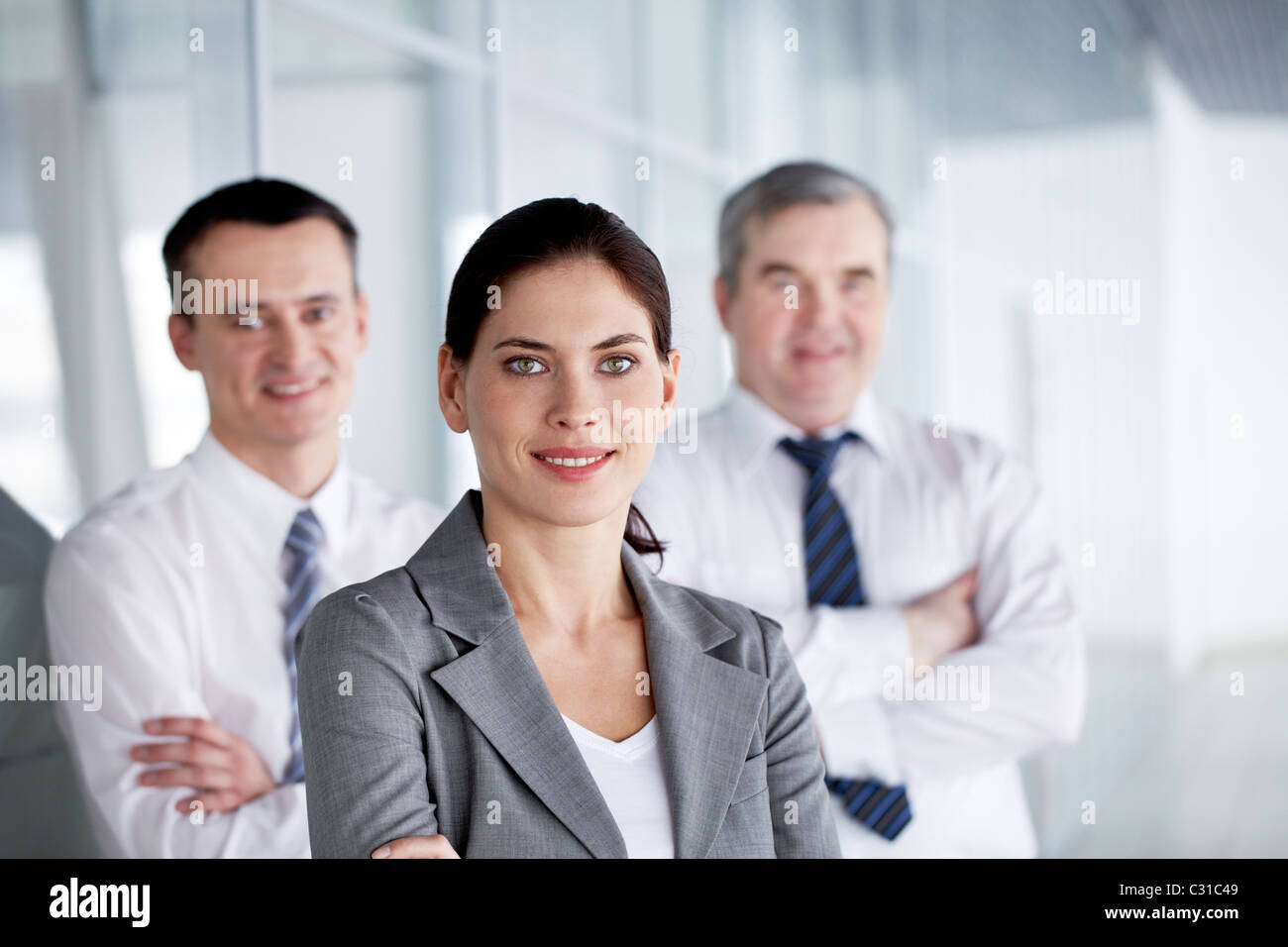 A business team with pretty leader in front looking at camera and ...