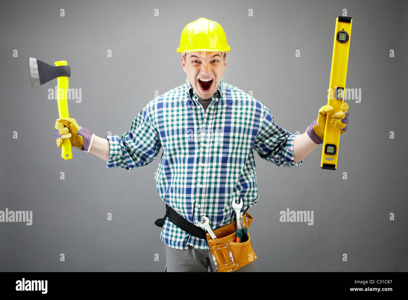 Portrait of crazy architect worker with axe and level measuring device ...
