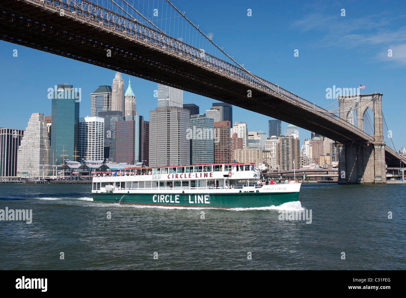 A CIRCLE LINE BOAT PASSING UNDER THE BROOKLYN BRIDGE, EAST RIVER ...