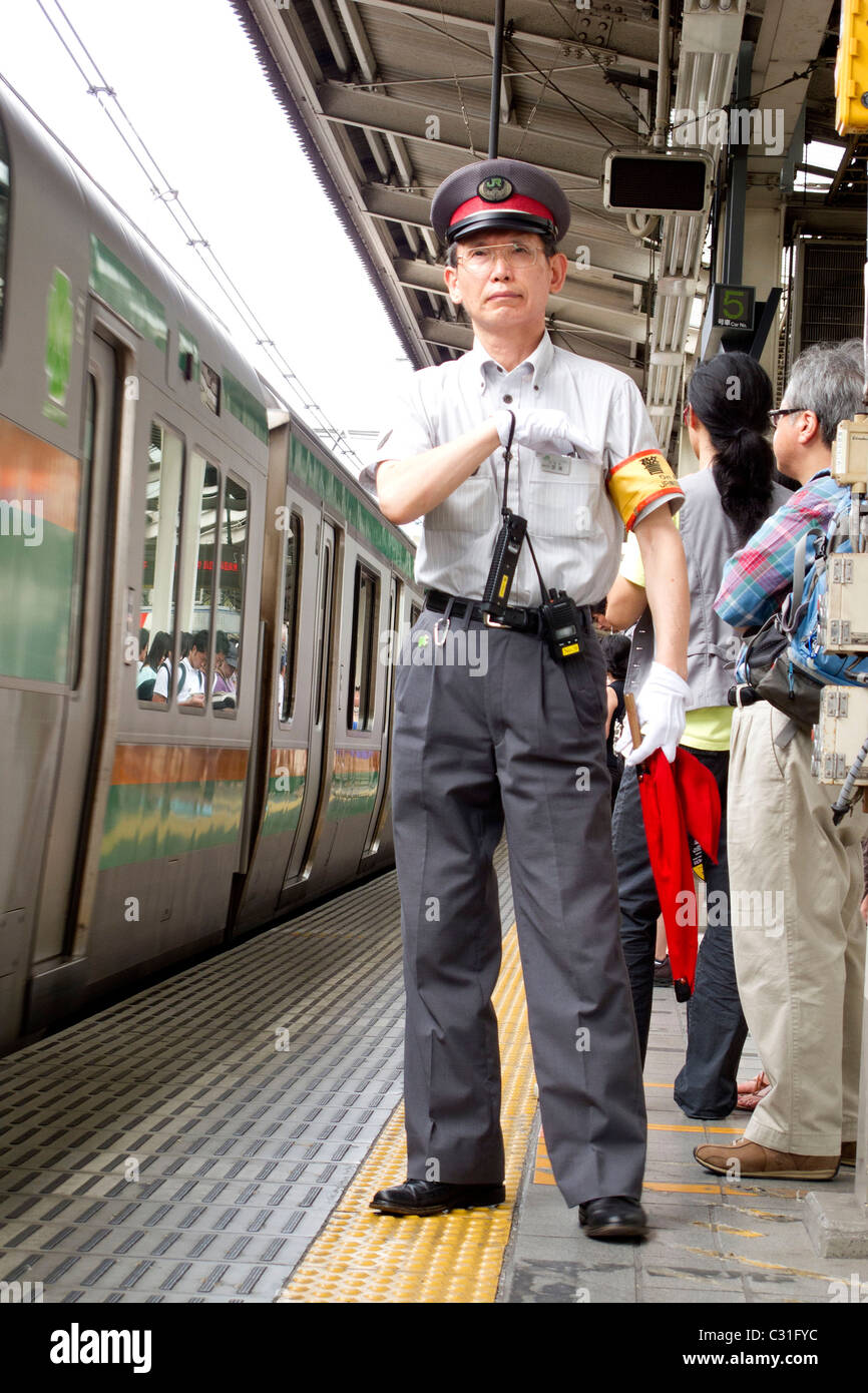 STATIONMASTER IN FRONT OF A TRAIN IN TOKYO’S MAIN TRAIN STATION, TOKYO ...