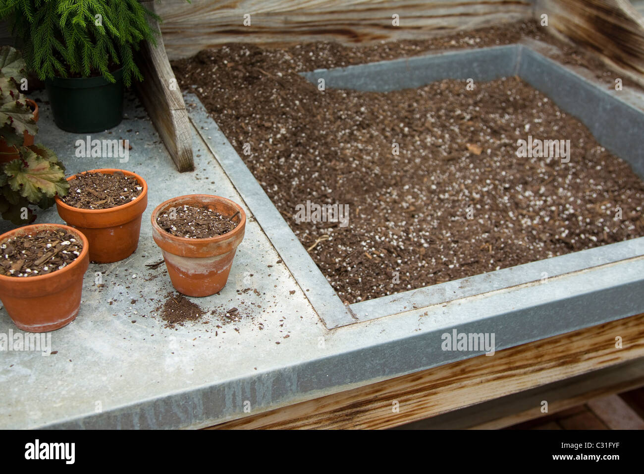 Soil and pots at a potting table Stock Photo - Alamy