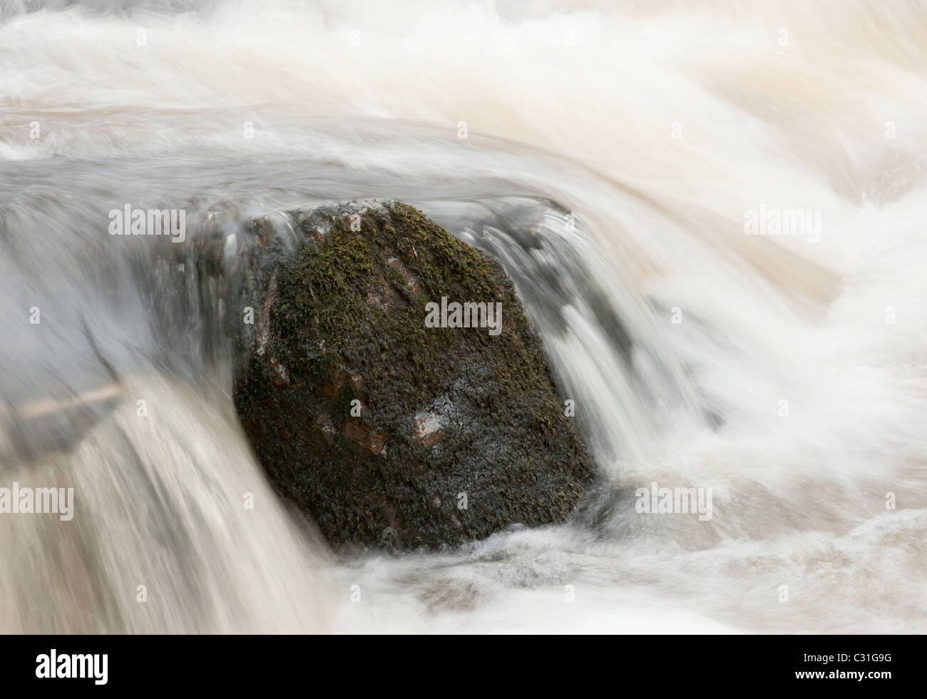 River water flowing around a rock Stock Photo - Alamy