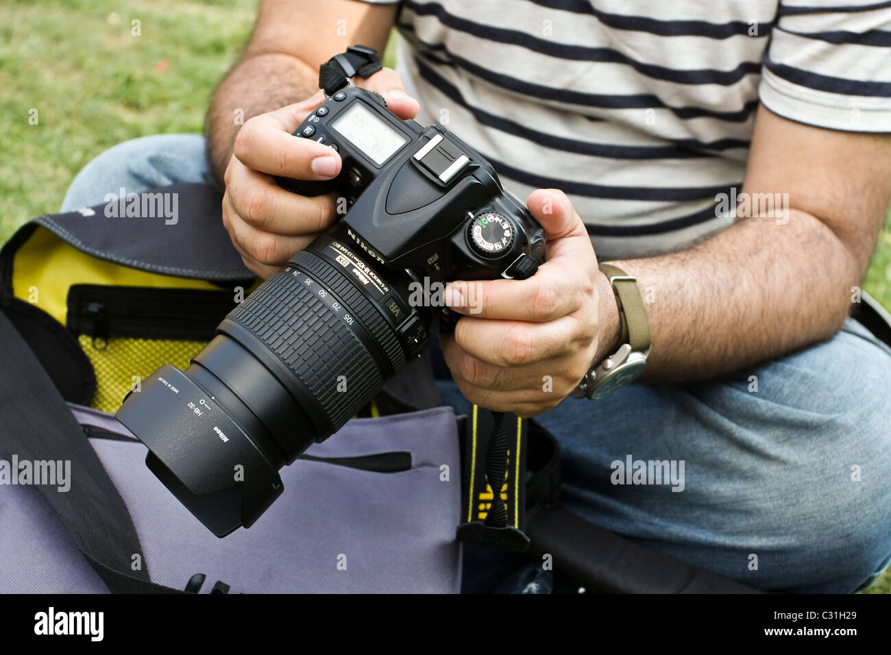 A keen male photographer examines his camera. Person is not ...