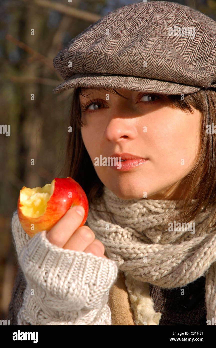 OUTDOORS IN AUTUMN, A YOUNG WOMAN BITING INTO AN APPLE Stock Photo - Alamy