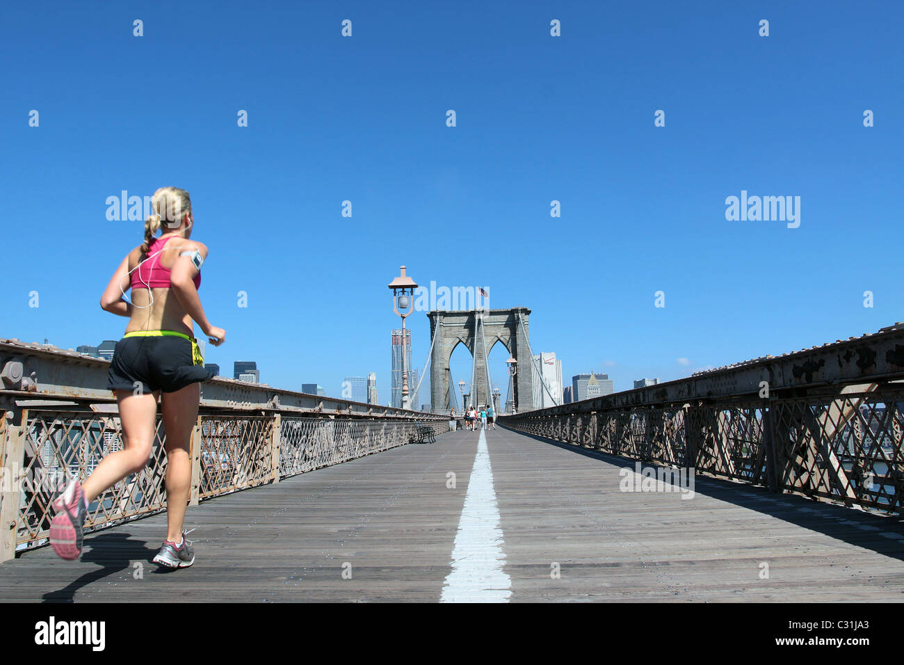 JOGGER CROSSING ON THE FOOTBRIDGE OF THE BROOKLYN BRIDGE, NEW YORK CITY ...