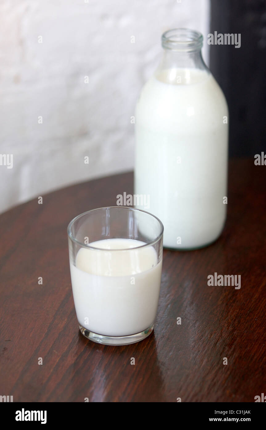 Glass of milk in front of a full milk bottle Stock Photo - Alamy