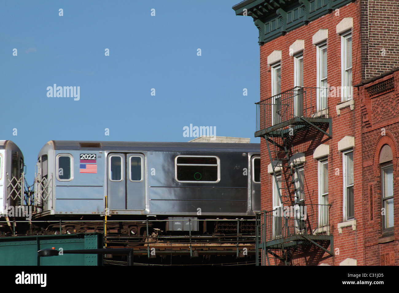 ELEVATED TRAIN ROCKING AN OLD BUILDING IN THE BOROUGH OF QUEENS, NEW ...