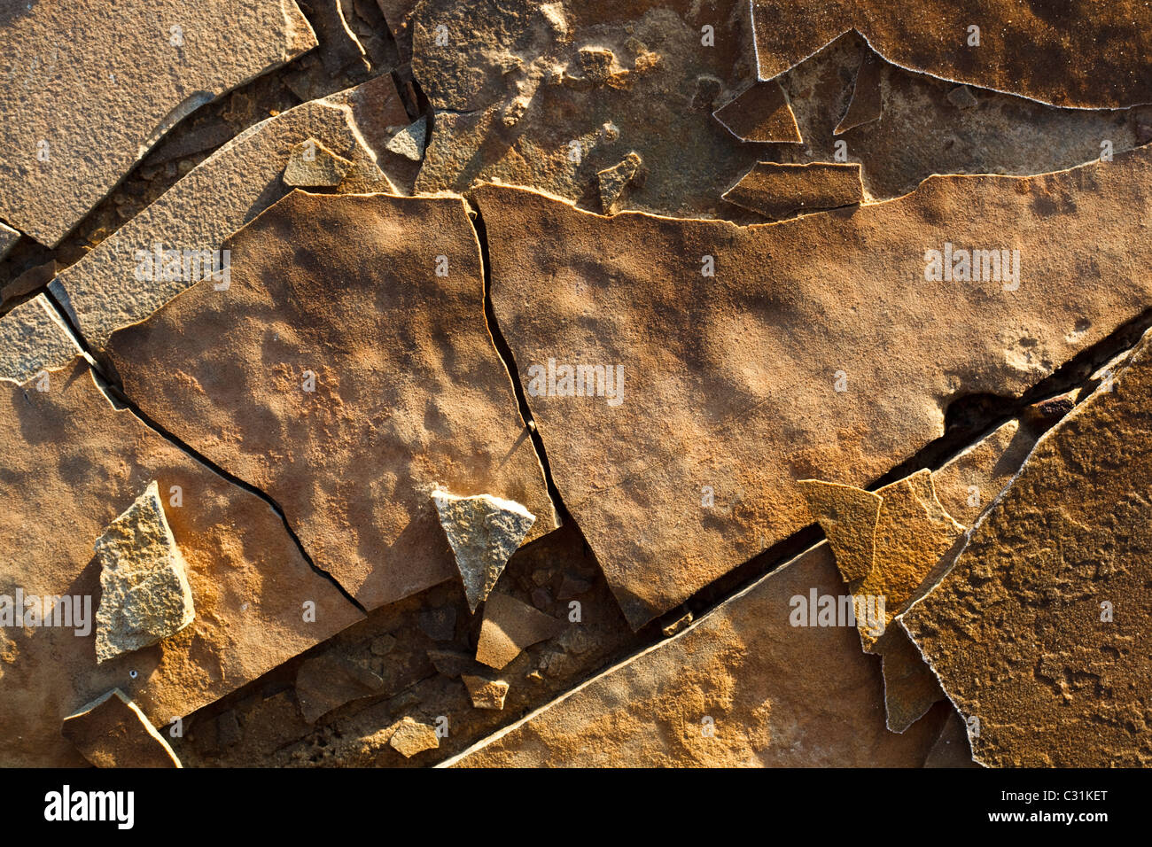Detail of rocks cracked by frost heave, and rimmed with frost, on a ...