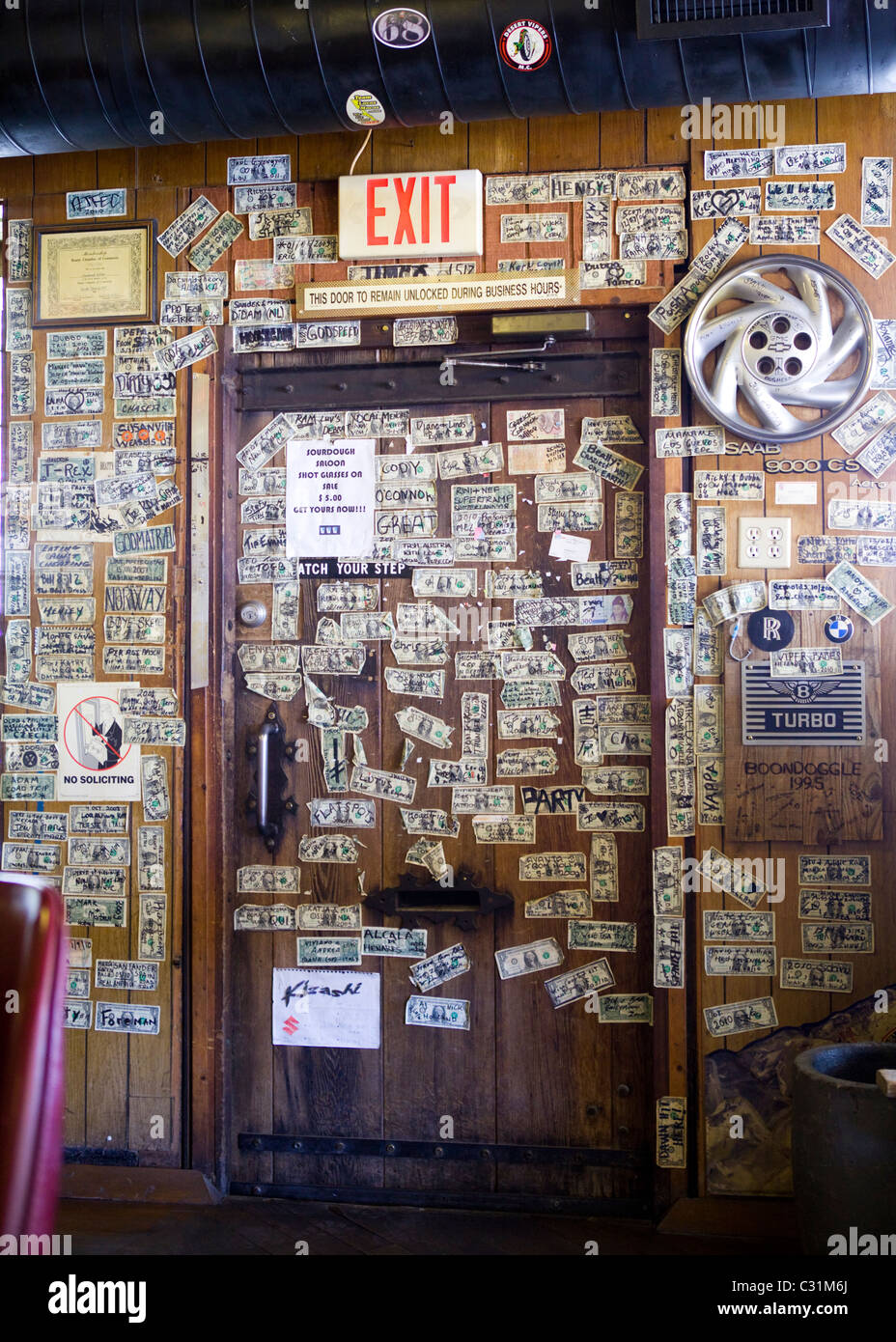 Signed one dollar bills tacked on the ceiling and walls of western bar ...
