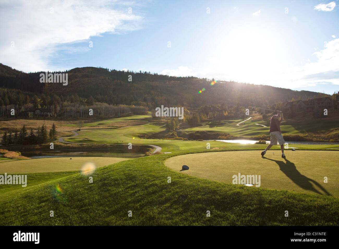 A golfer drives at sunset in Colorado Stock Photo - Alamy