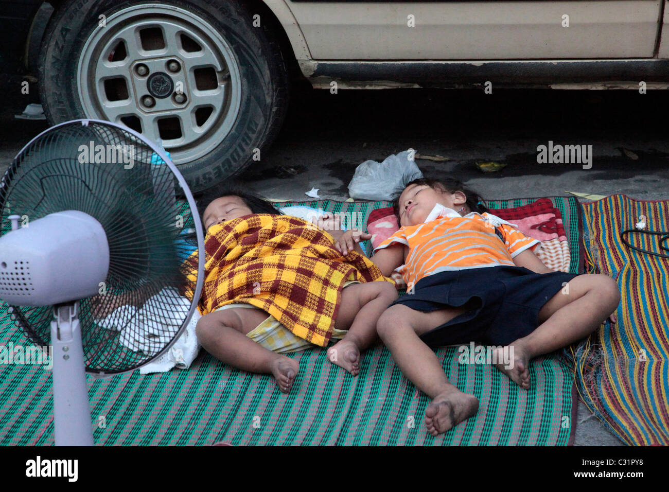 CHILDREN SLEEPING ON THE STREET NEAR A FAN, BANGKOK, THAILAND, ASIA ...