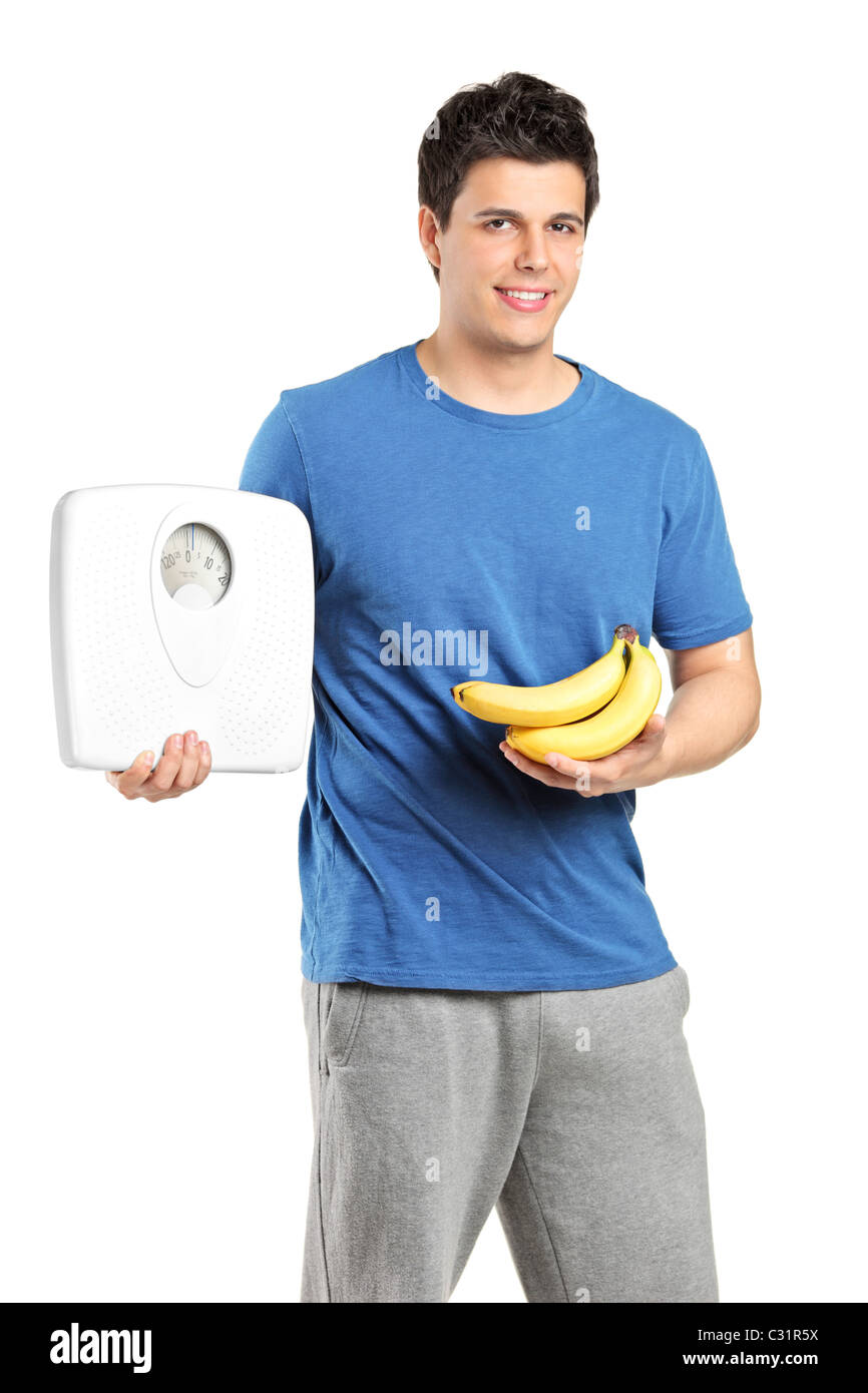 A young male athlete holding a weight scale and bananas Stock Photo - Alamy