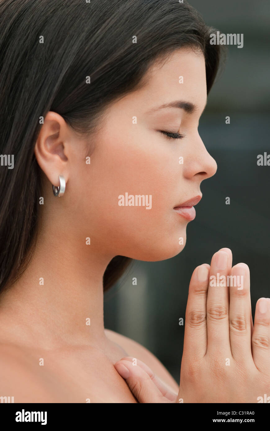 Hispanic woman praying Stock Photo - Alamy