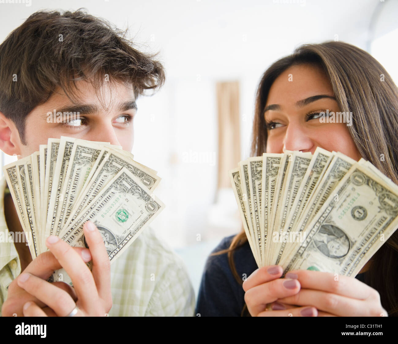 Couple holding handfuls of money Stock Photo - Alamy