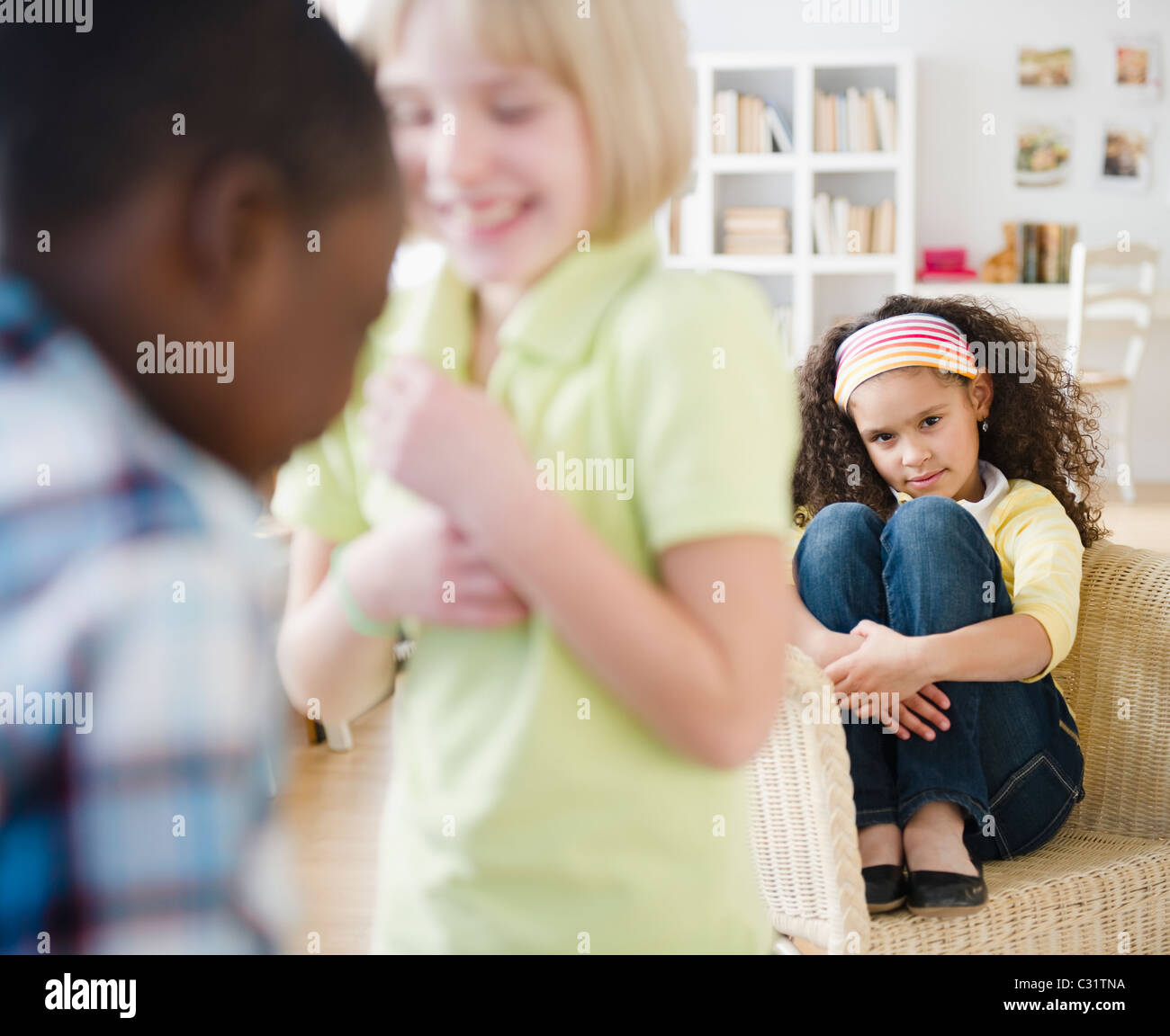 Lonely girl watching friends playing Stock Photo - Alamy