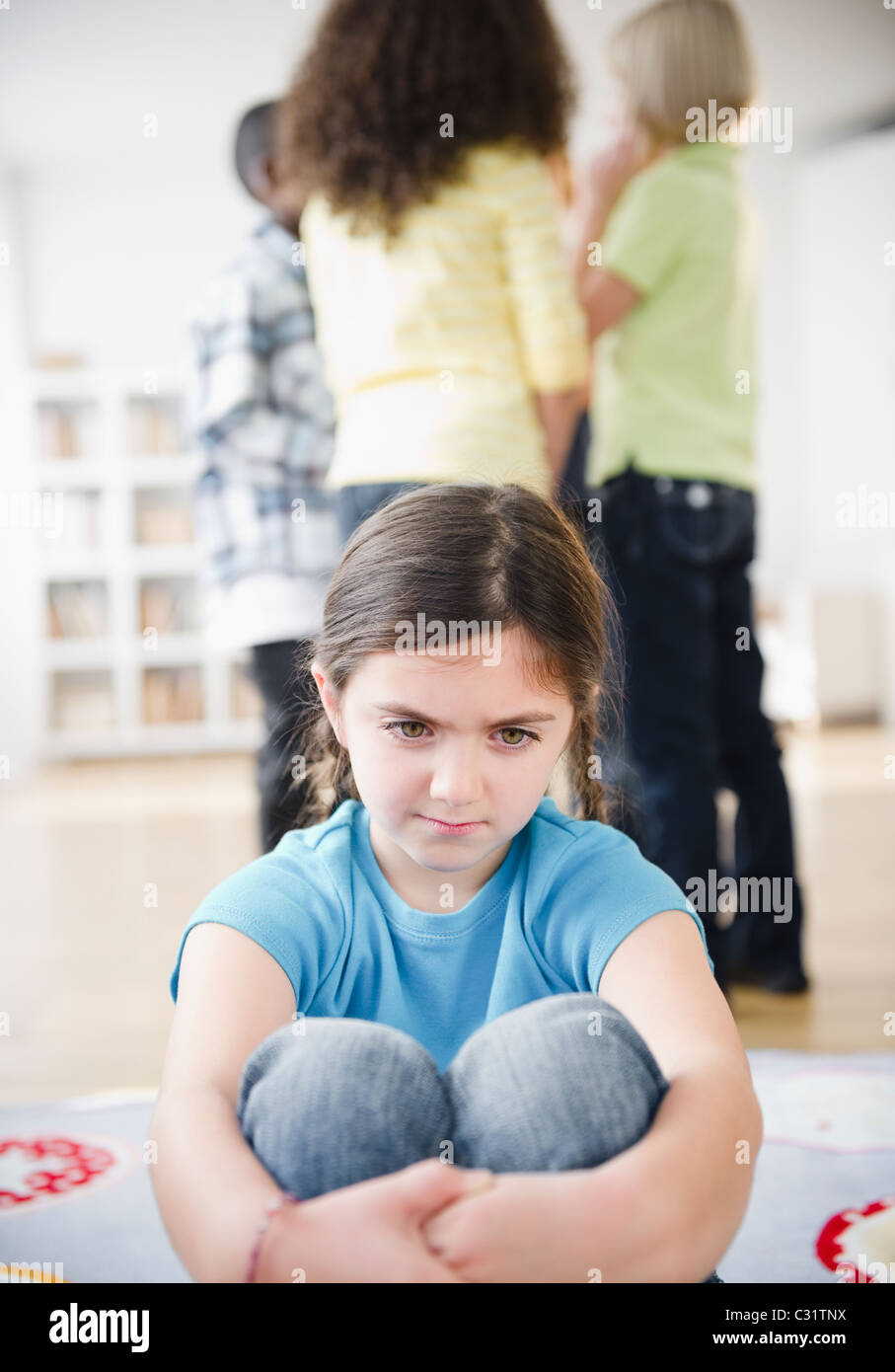 Lonely girl ignoring friends playing Stock Photo - Alamy