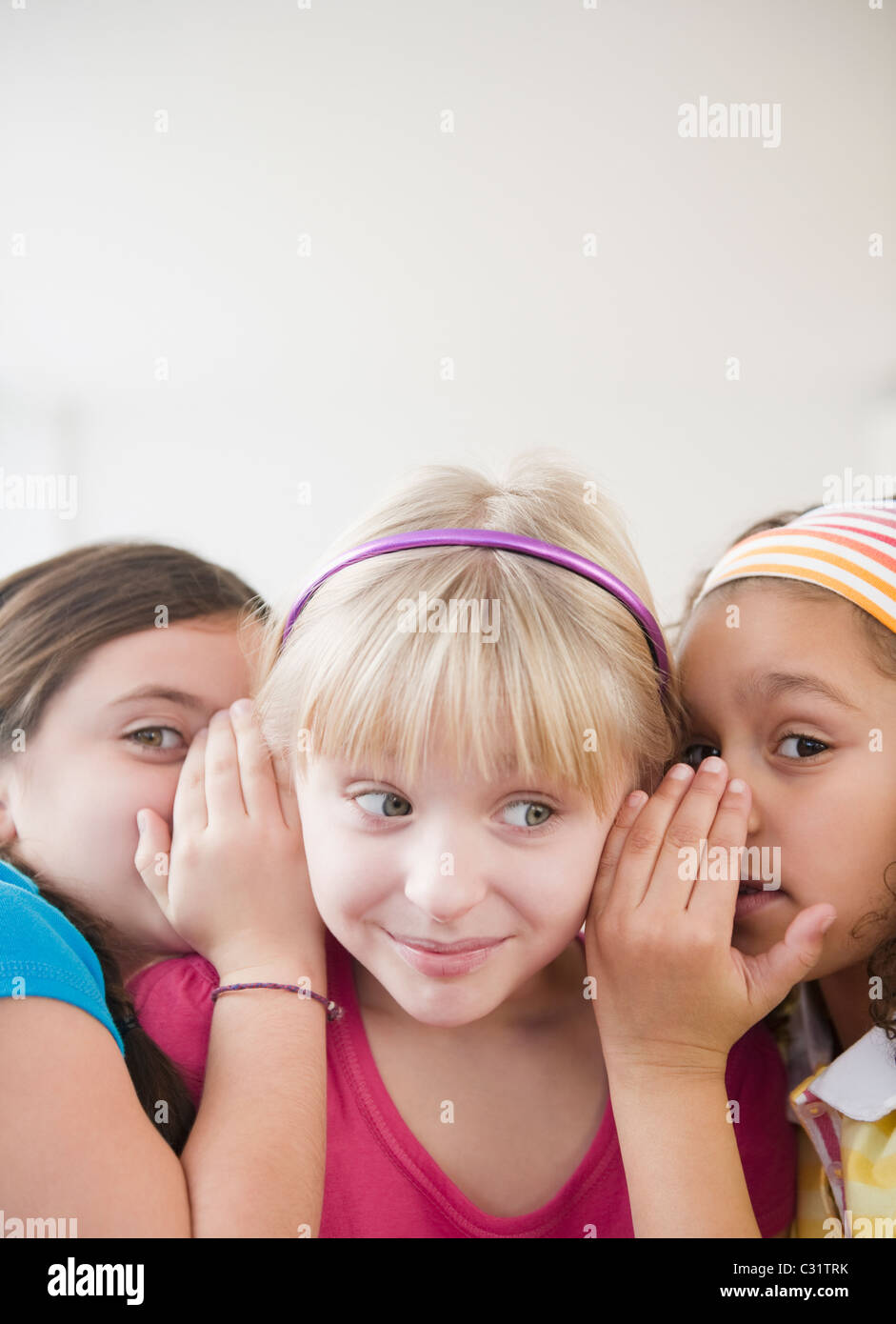 Girls whispering together Stock Photo - Alamy