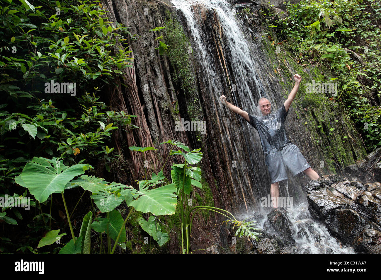 COOLING OFF UNDER A WATERFALL, TREKKING IN THE JUNGLE, NATURE RESERVE ...