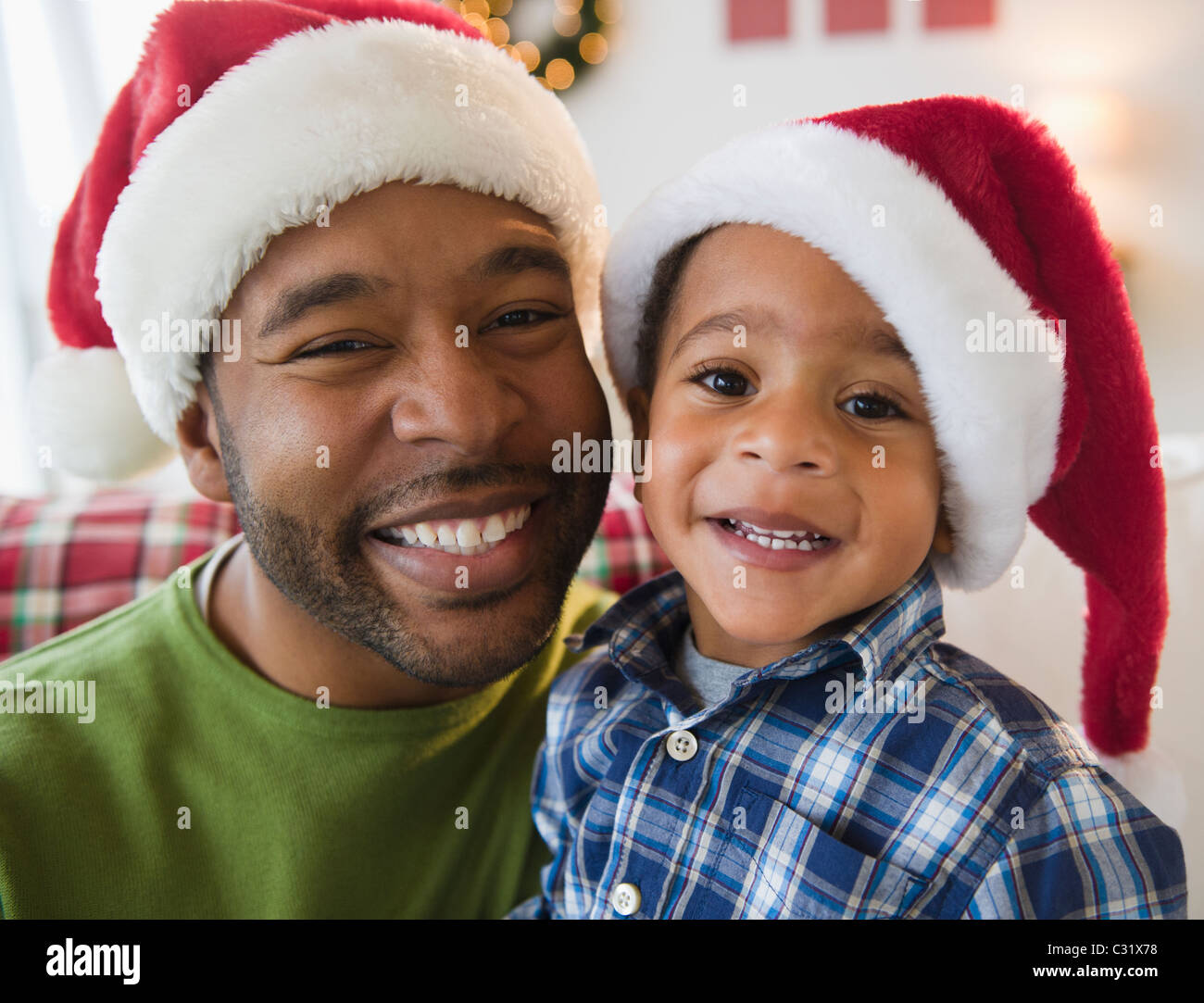 Black father and son wearing Santa hats Stock Photo - Alamy