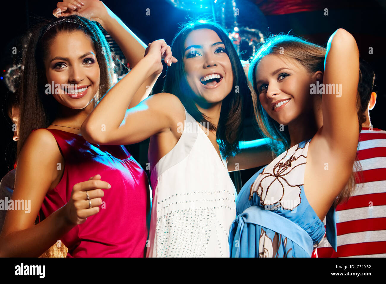 Group of fashionable girls dancing energetically in night club Stock ...
