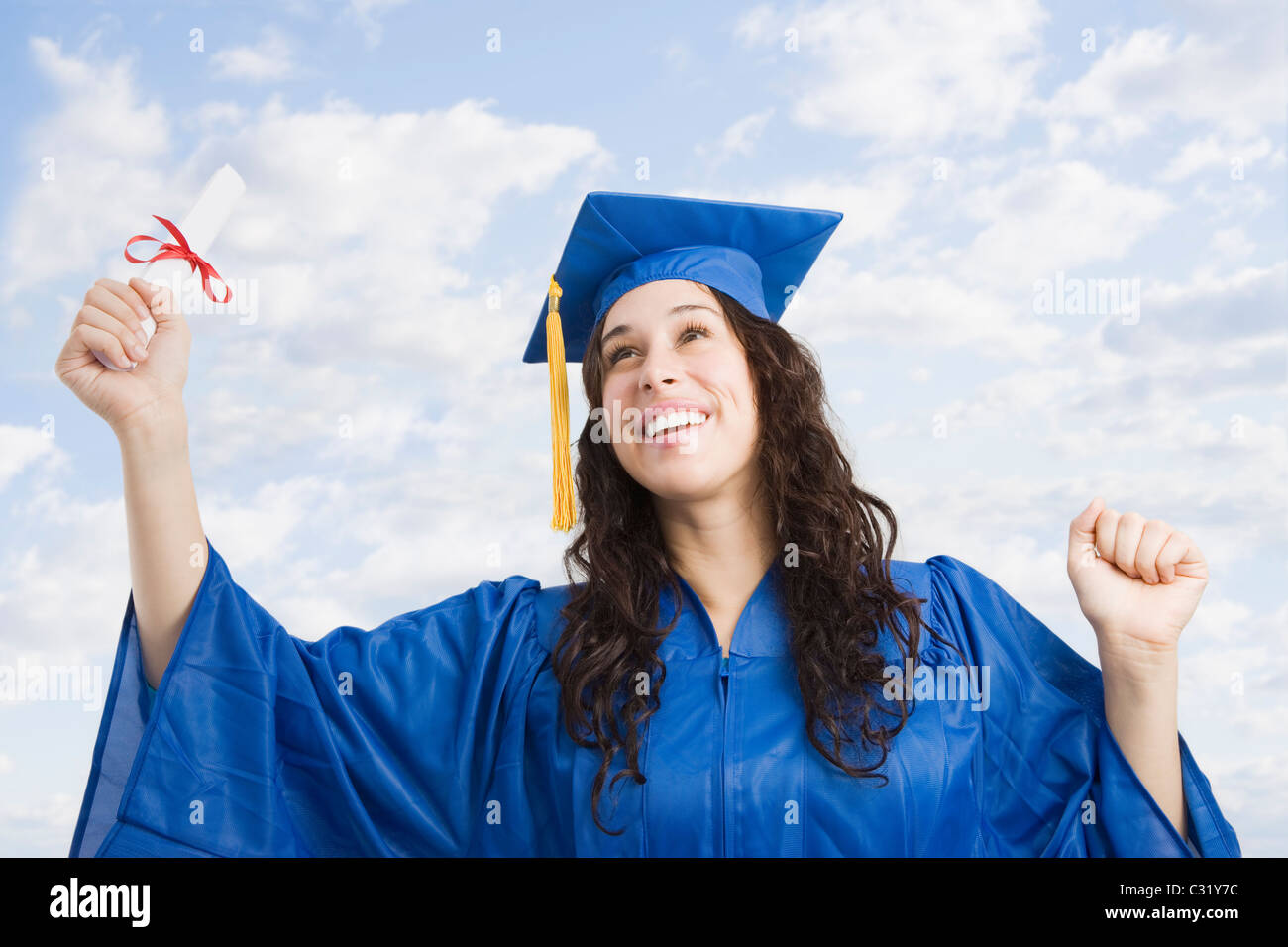 Mixed race woman wearing graduation cap and gown holding diploma Stock ...