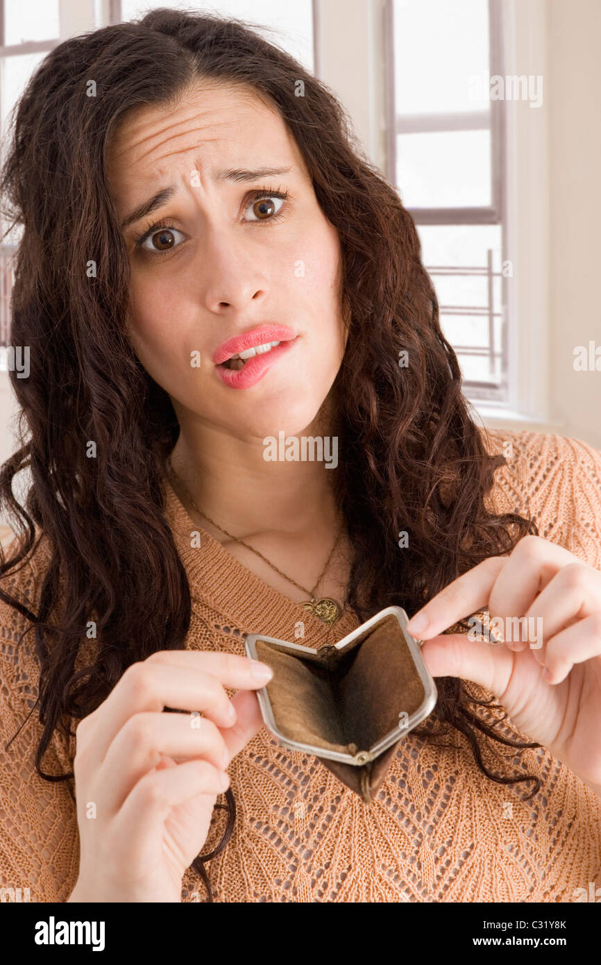 Mixed race woman opening empty coin purse Stock Photo - Alamy