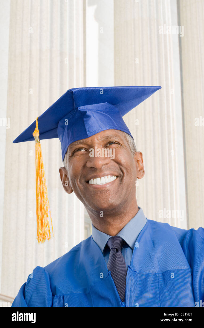 Mixed race man in graduation cap and gown Stock Photo - Alamy