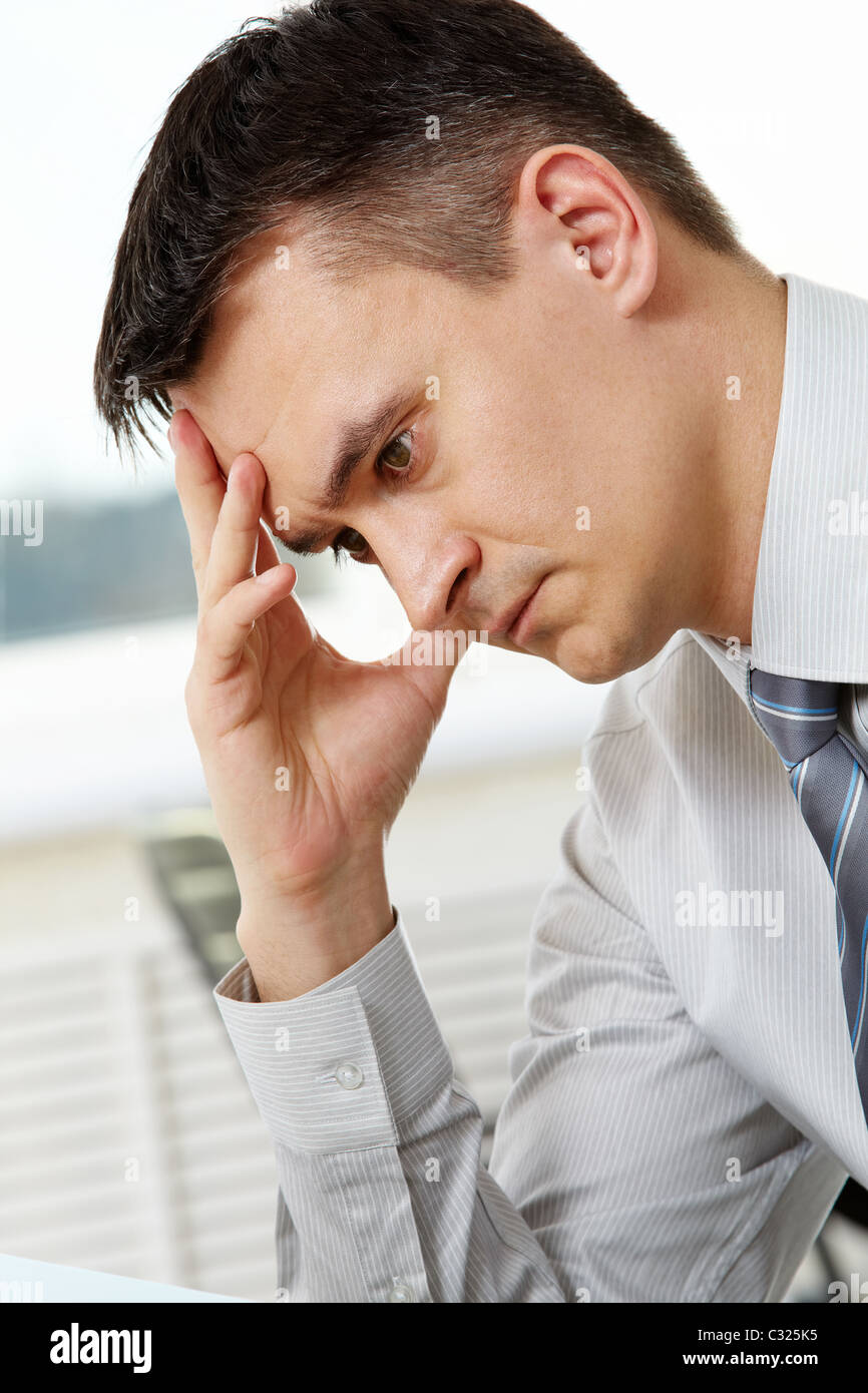 Portrait of tired man touching his head Stock Photo - Alamy