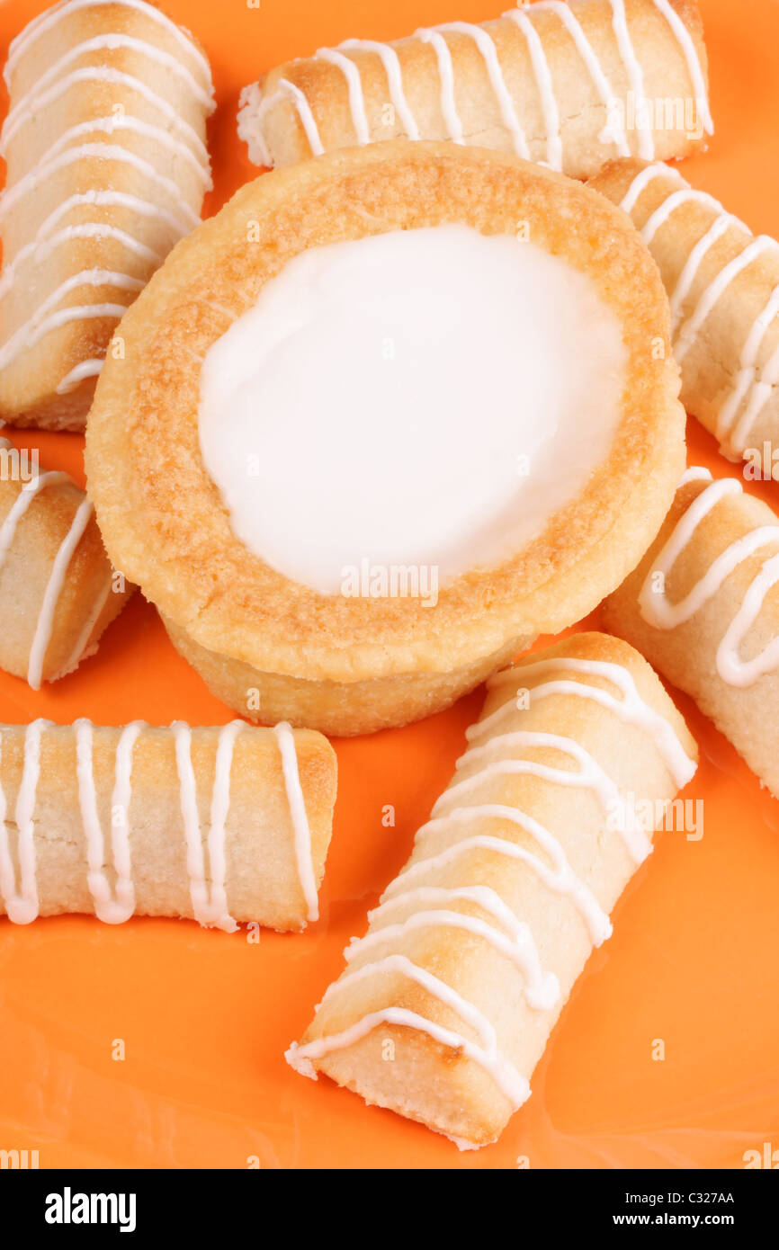 Swedish almond tart and danish macaroon fingers on a orange plate Stock ...
