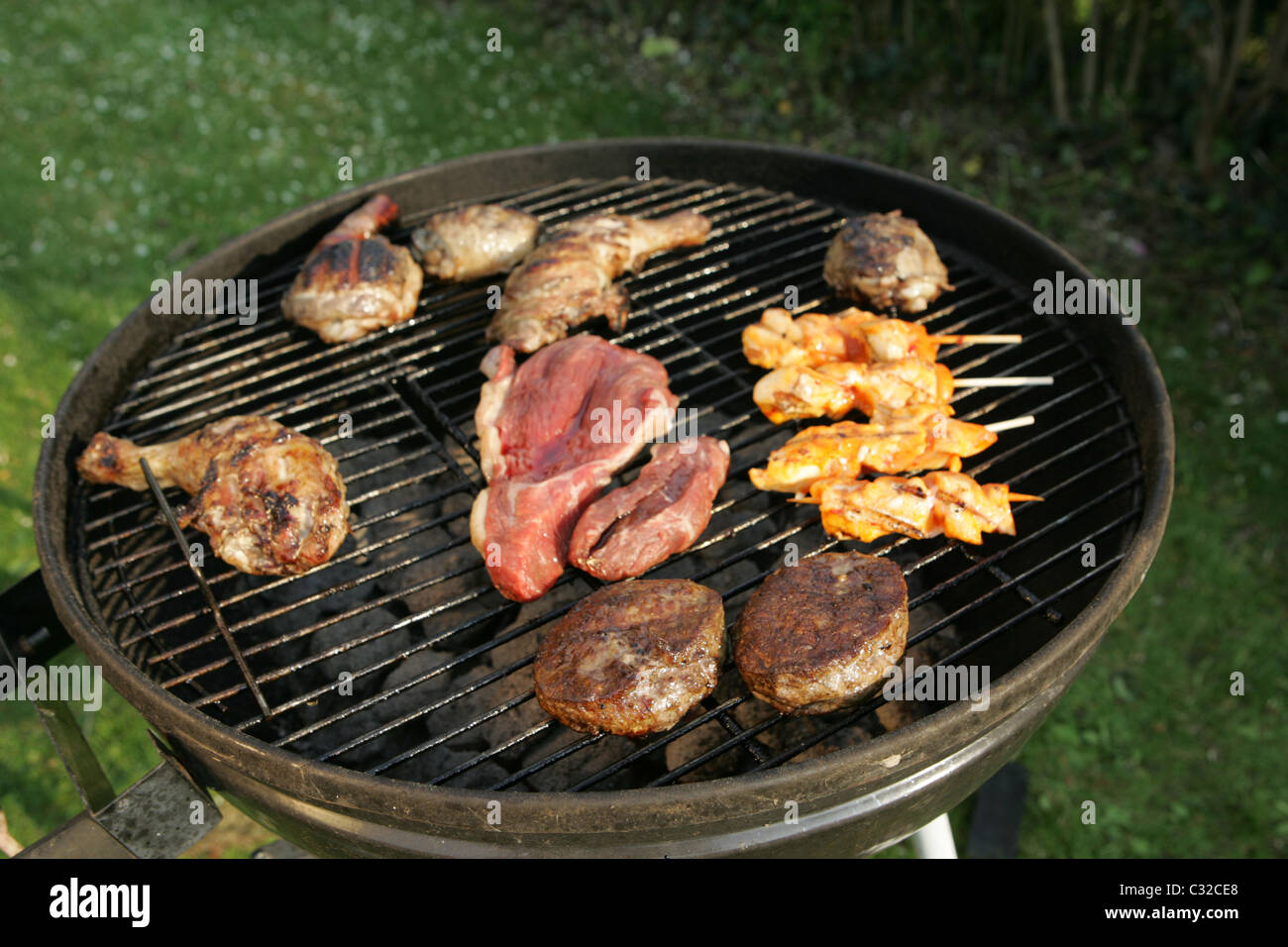 BBQ with selection of meat - burgers in focus Stock Photo - Alamy
