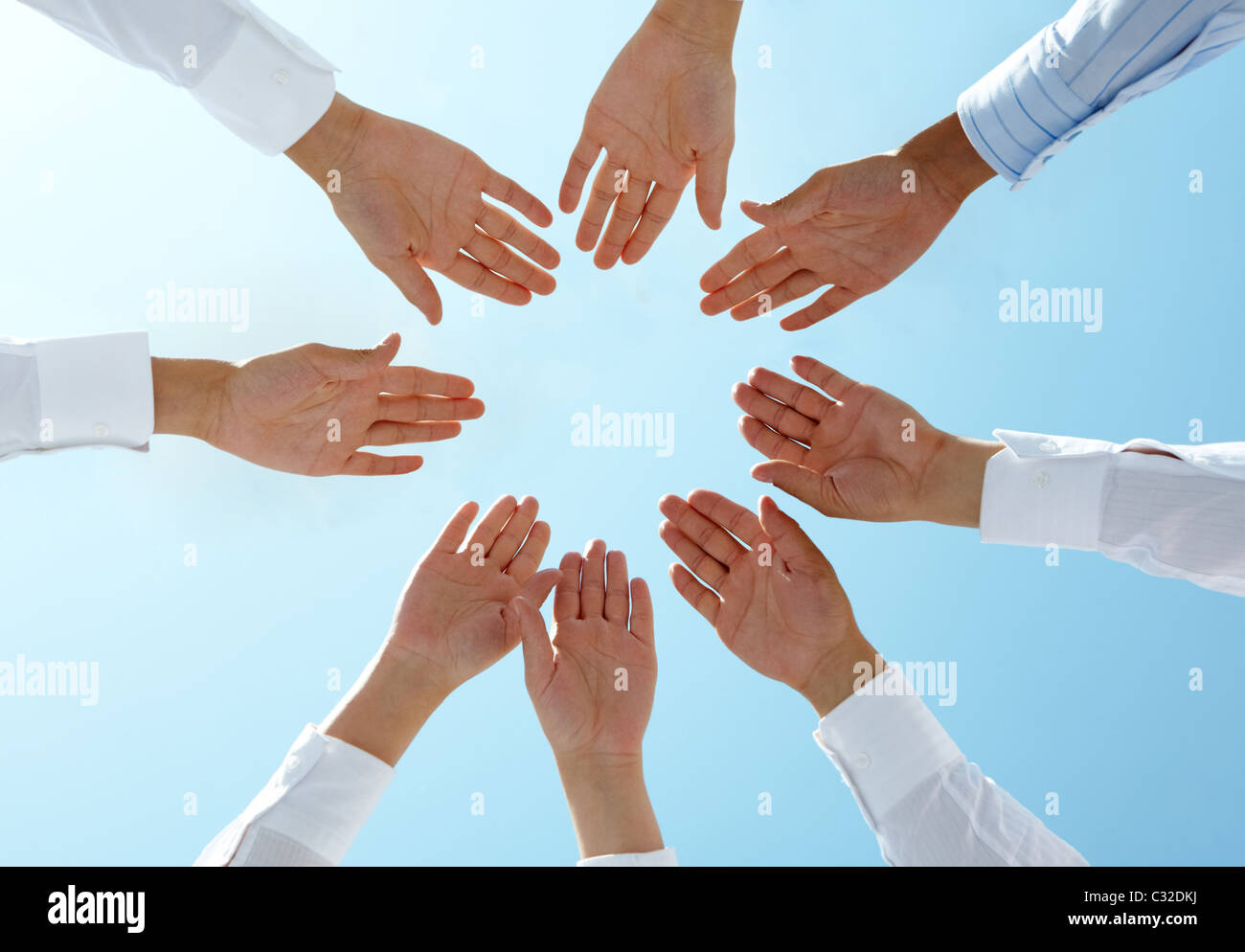 Below angle of circle of people hands with blue sky above Stock Photo ...