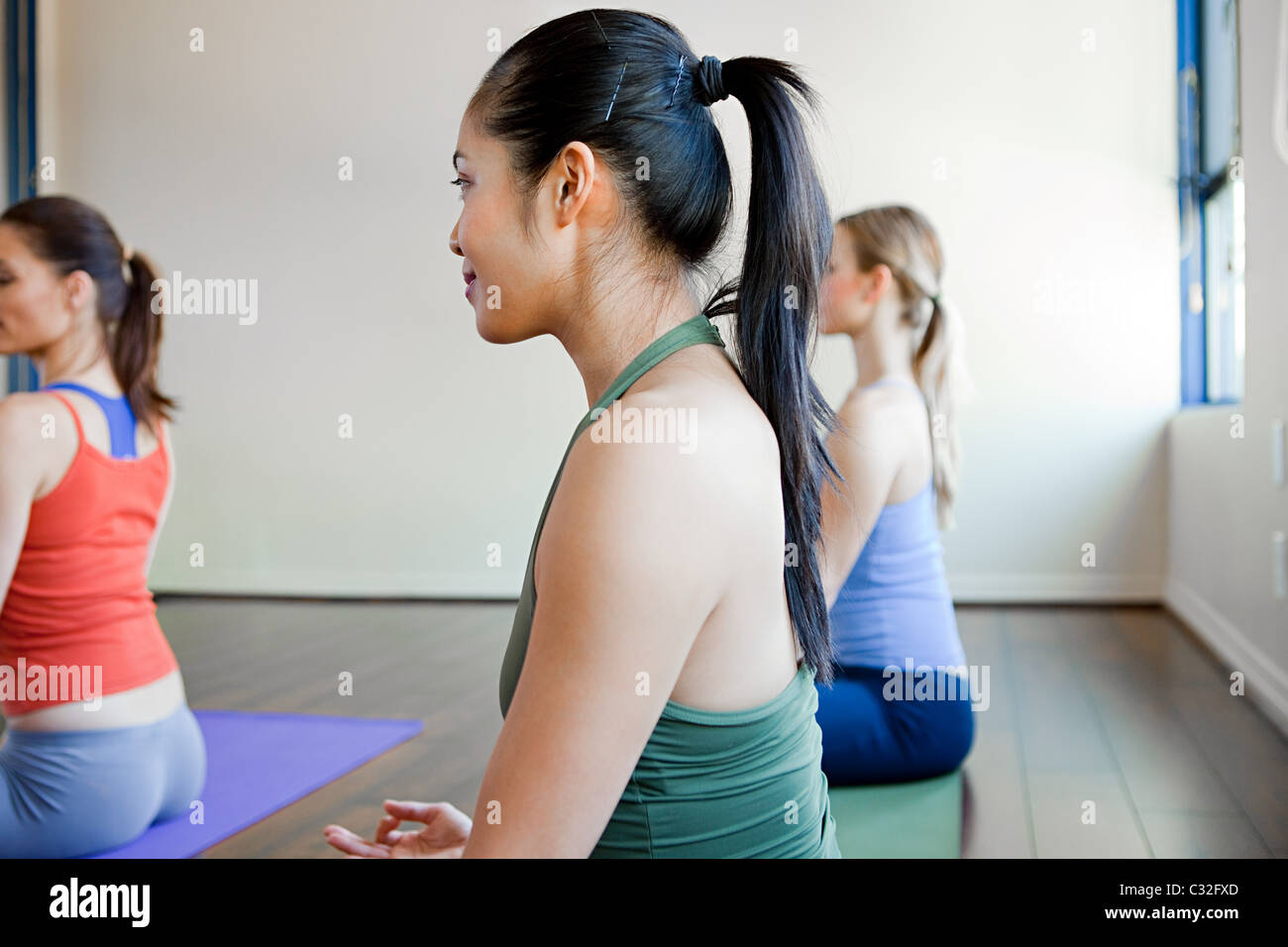 Three women doing yoga class Stock Photo - Alamy
