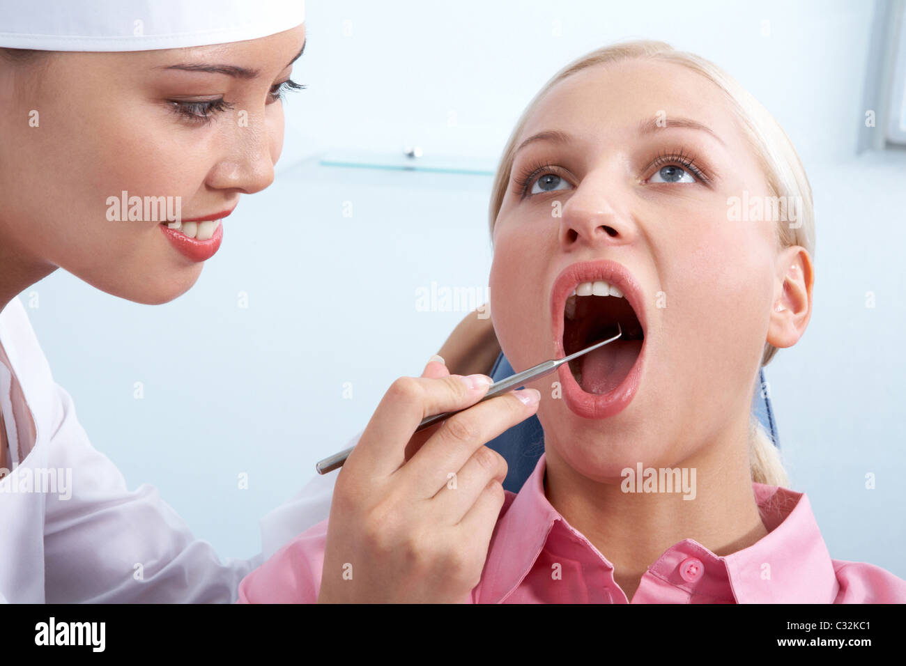 Image of young woman during inspection of oral cavity with help of hook ...